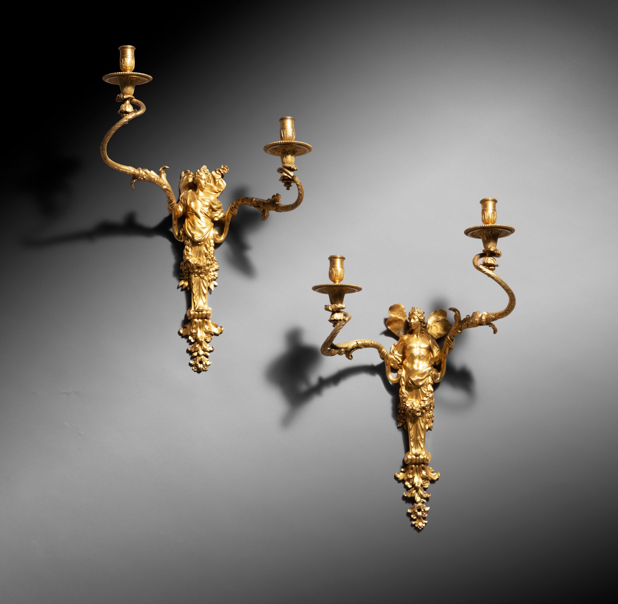 A pair of French Régence giltbronze wall-lights, Flora and Zephir ...