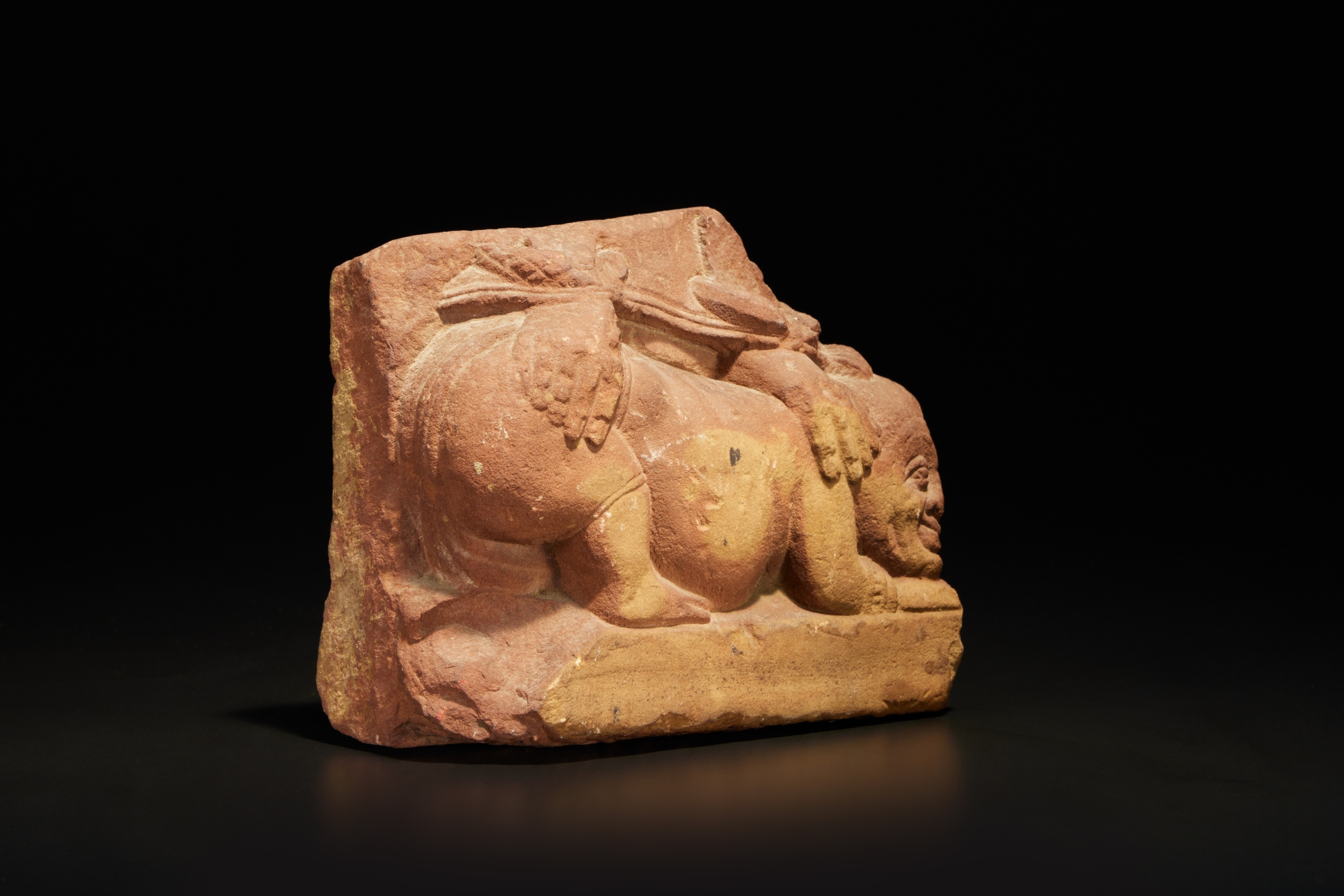 A mottled red sandstone carving of Yakshini resting on a dwarf, Central ...