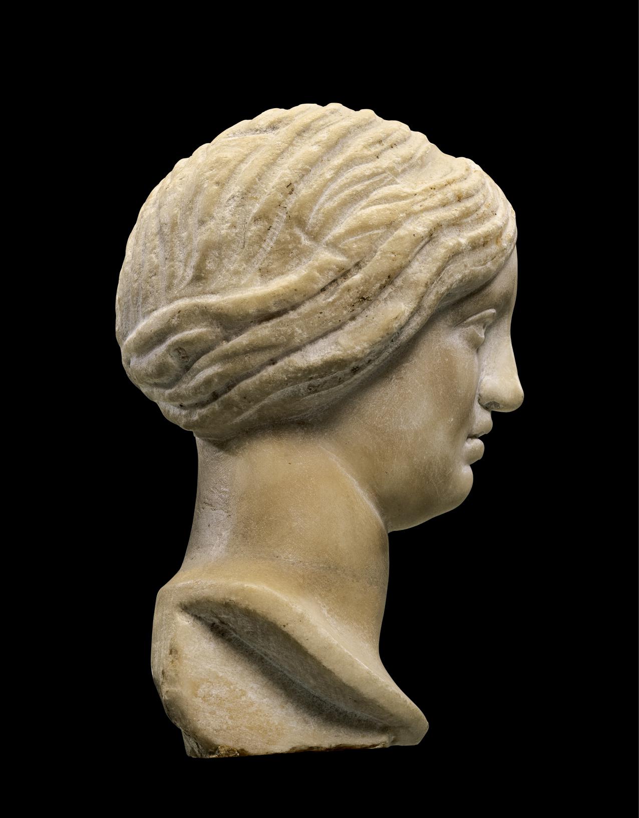 A LATE ROMAN MARBLE HEAD OF A WOMAN OR GODDESS, CIRCA 4TH CENTURY A.D ...