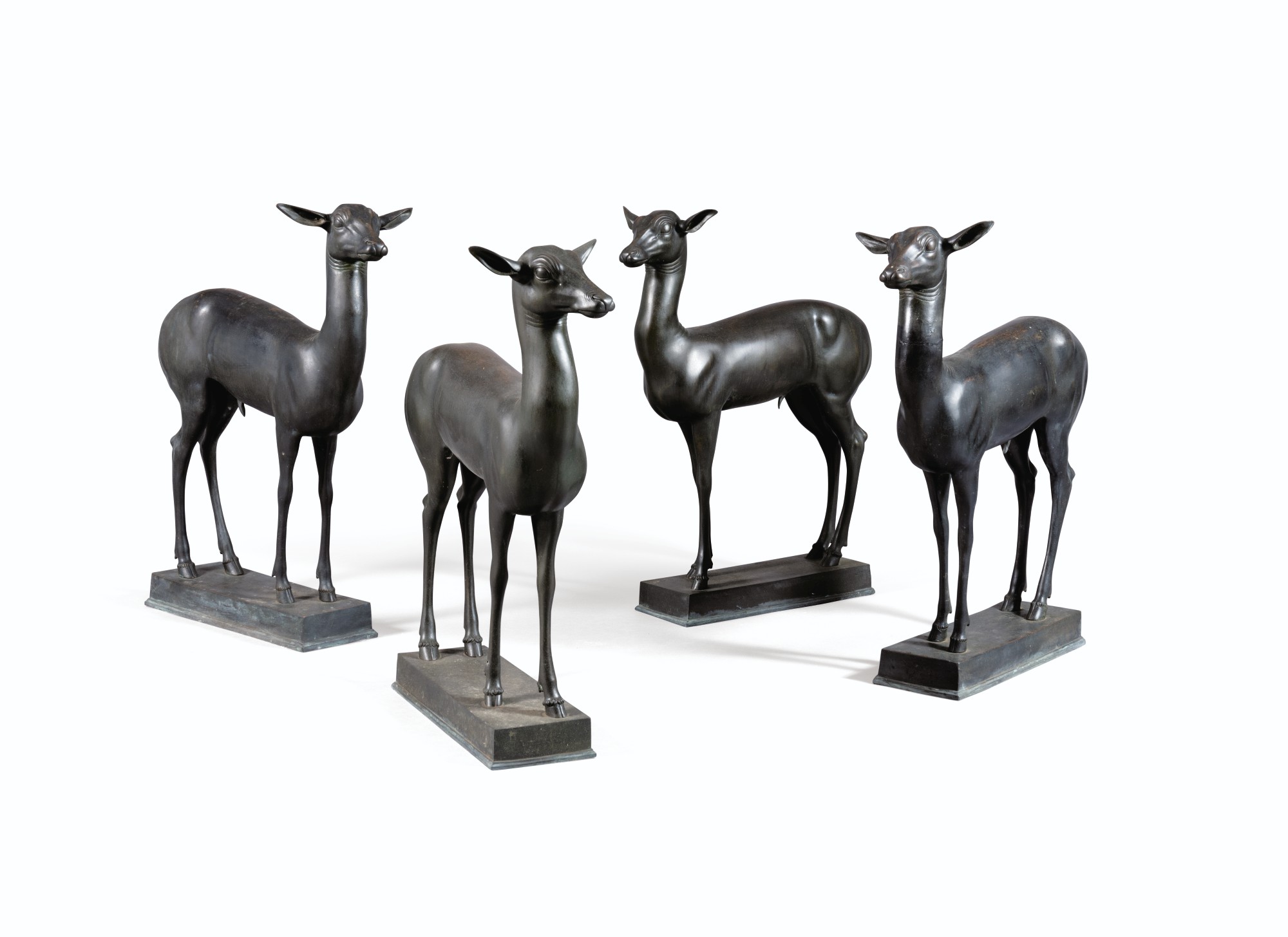 A SET OF FOUR PATINATED BRONZE FALLOW DEER, AFTER AN ANTIQUE MODEL OF ...