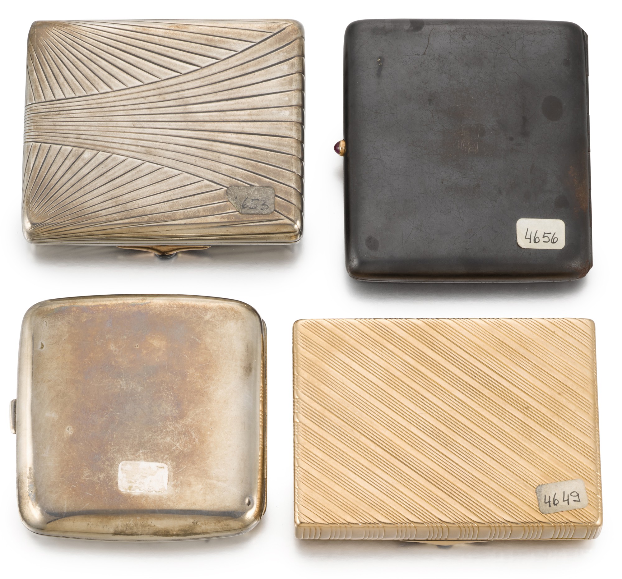 A group of four gold, silver and gunmetal Russian cigarette cases ...