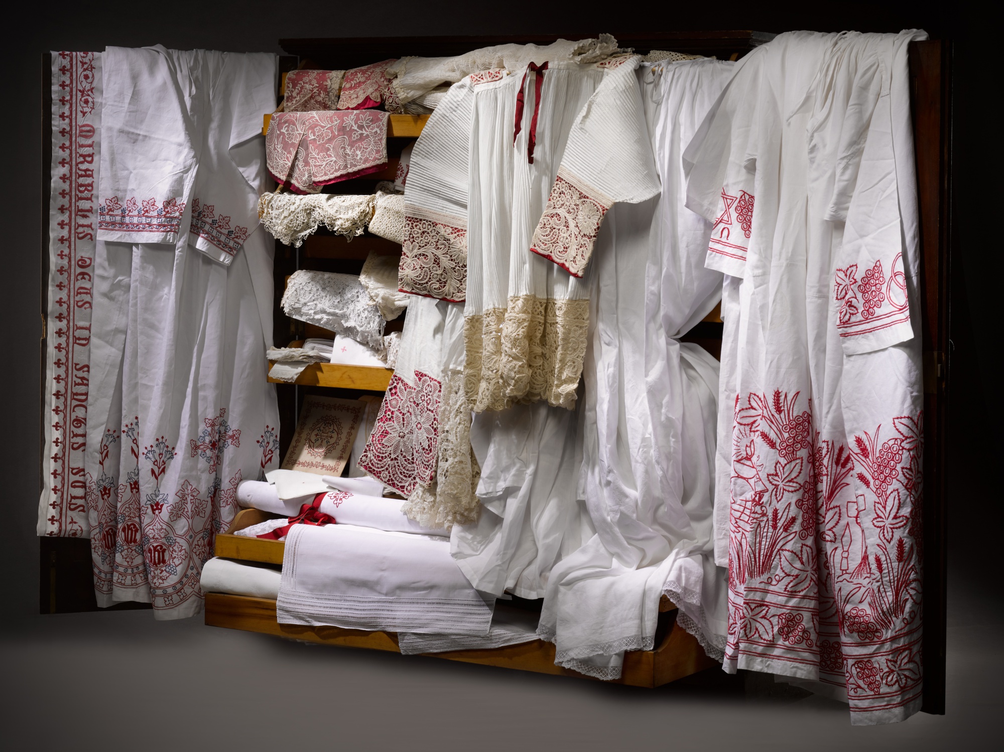 A group of linen and lace vestments and linen church service ...