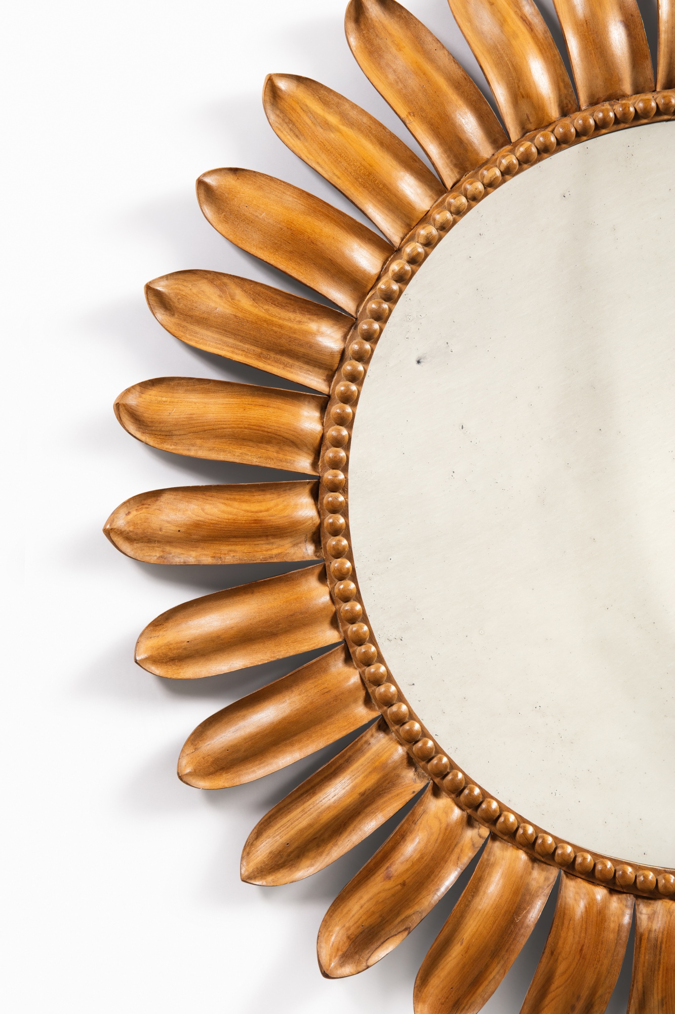 A large carved wood lotus petal mirror, designed by Andrew Allfree (b ...