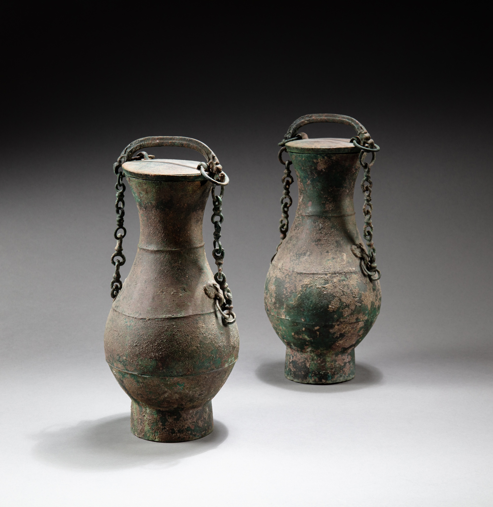A rare pair of archaic bronze lidded vases with chain handle, Late ...