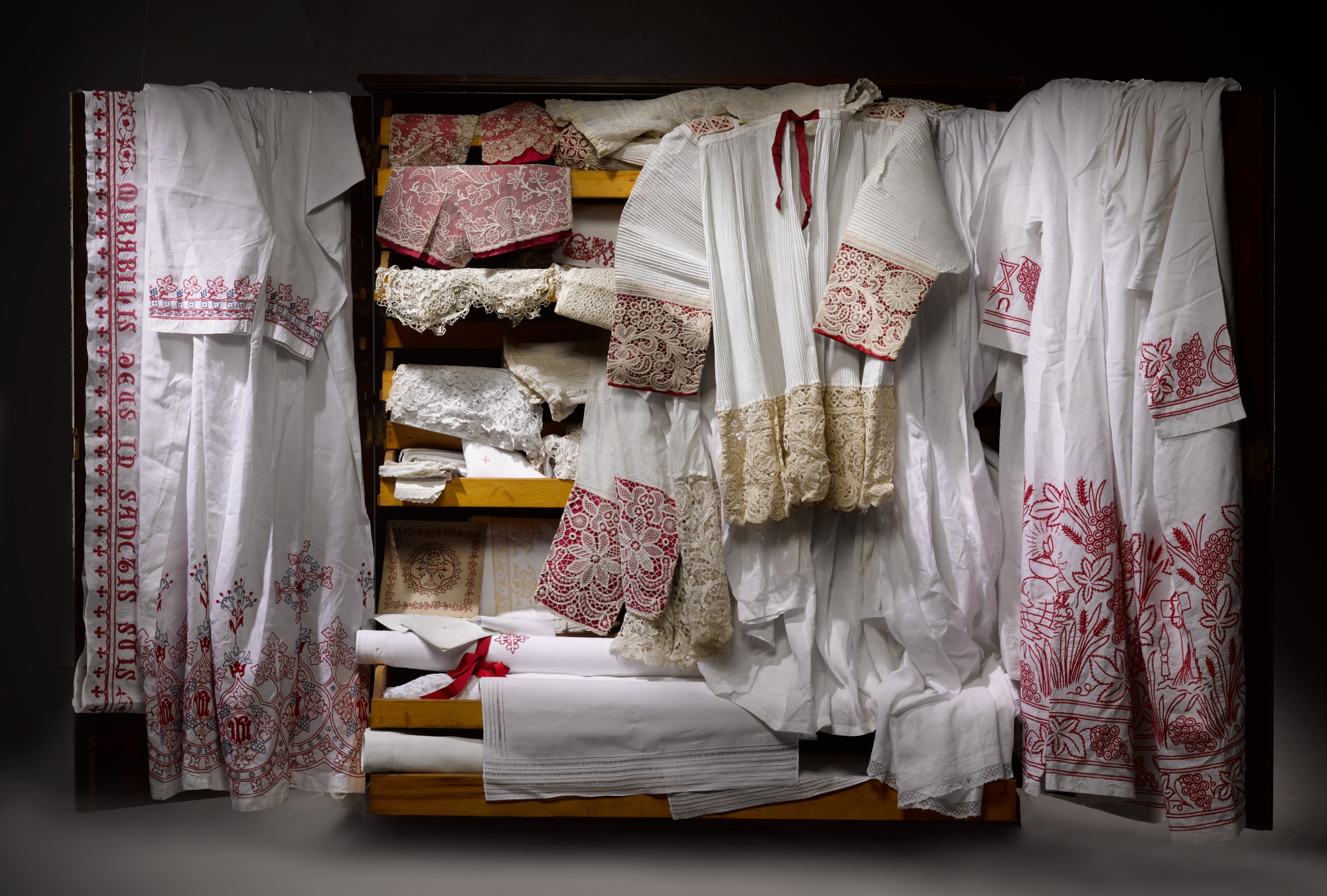 A group of linen and lace vestments and linen church service ...