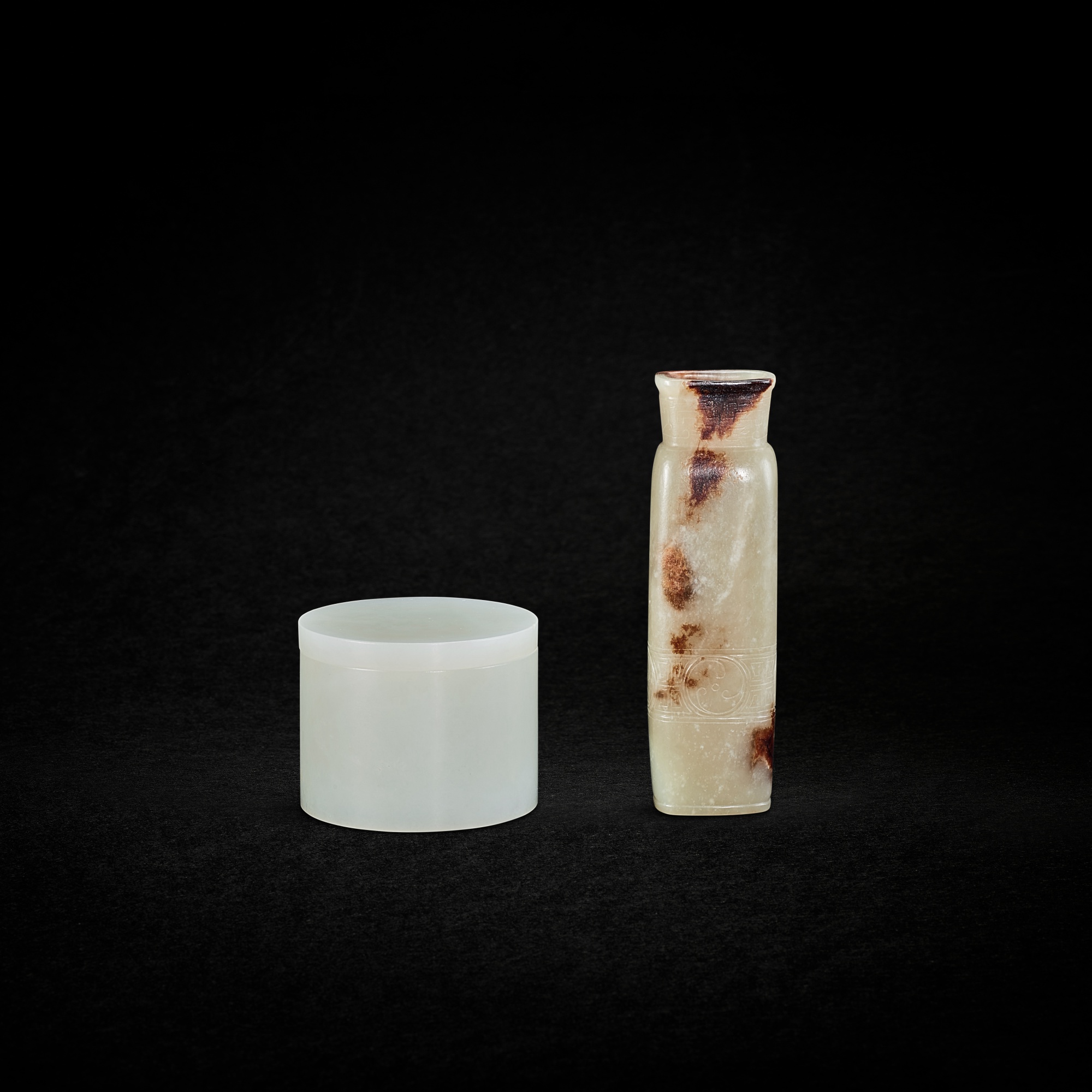A small celadon and russet jade vase and a white jade box and cover ...