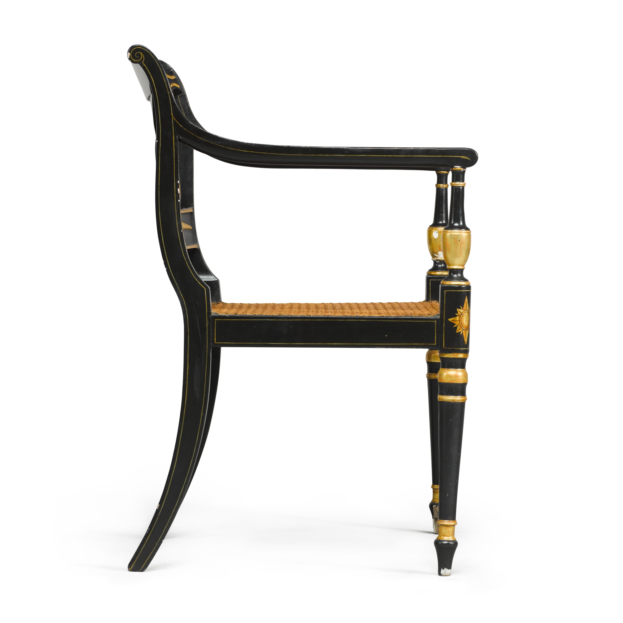 A late George III ebonised and parcel-gilt armchair, in the Egyptian ...