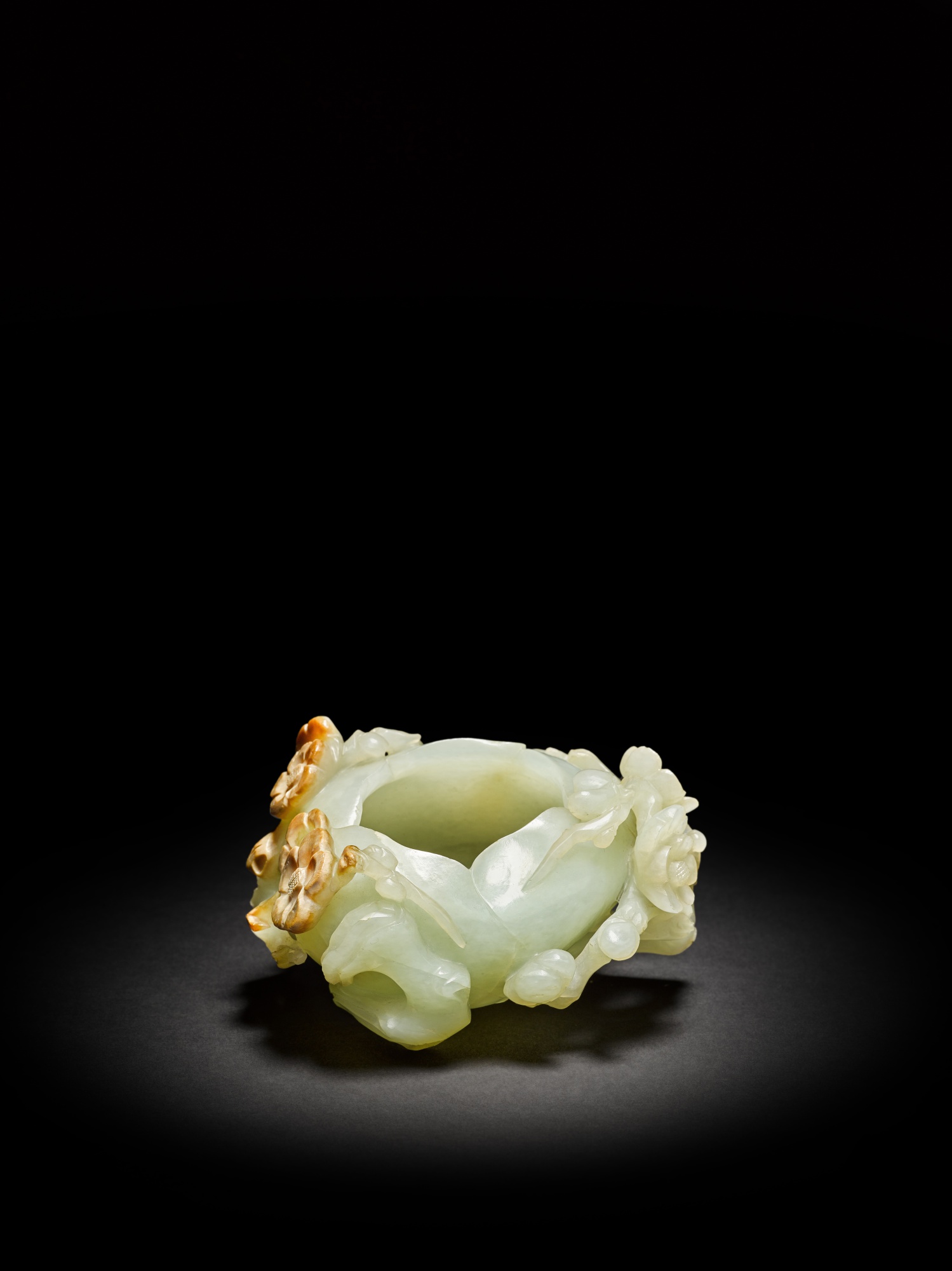 A pale celadon and russet jade 'peony' washer, 17th - 18th century ...