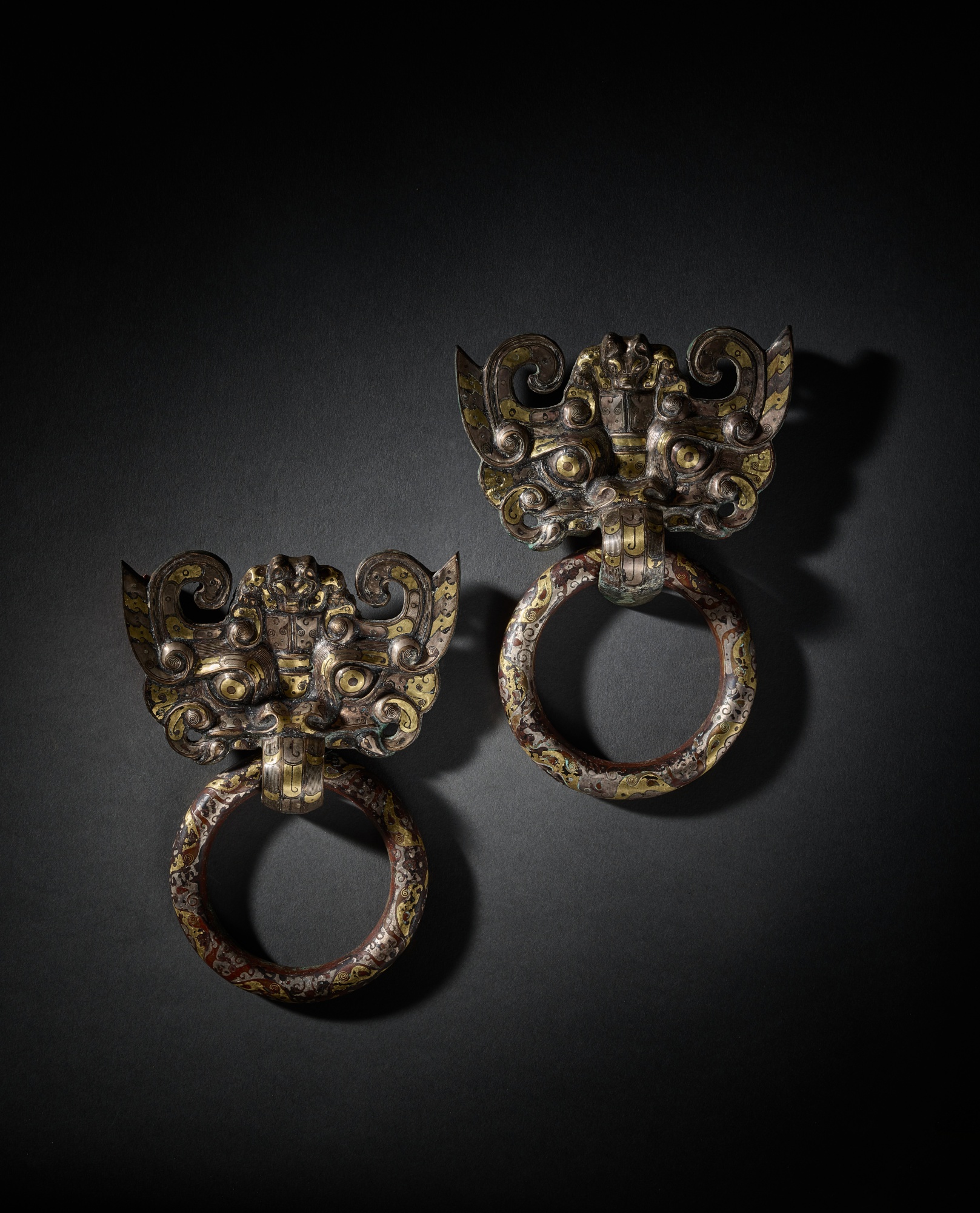 A pair of rare and exceptional gold and silver-inlaid masks and ring ...