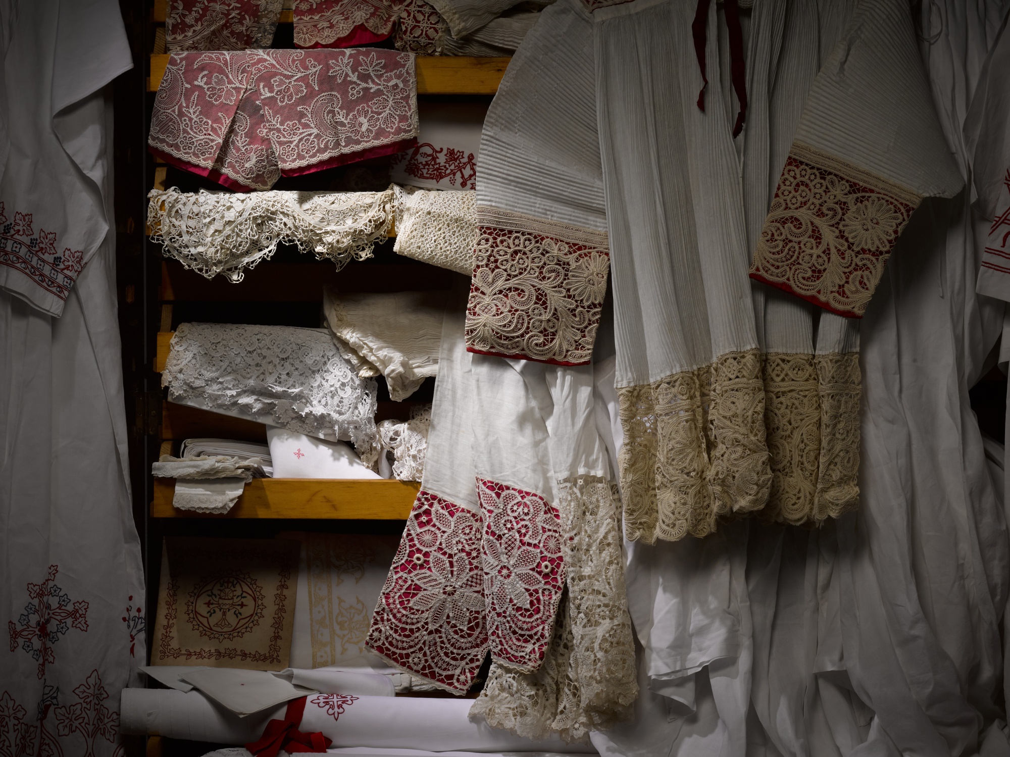 A group of linen and lace vestments and linen church service ...