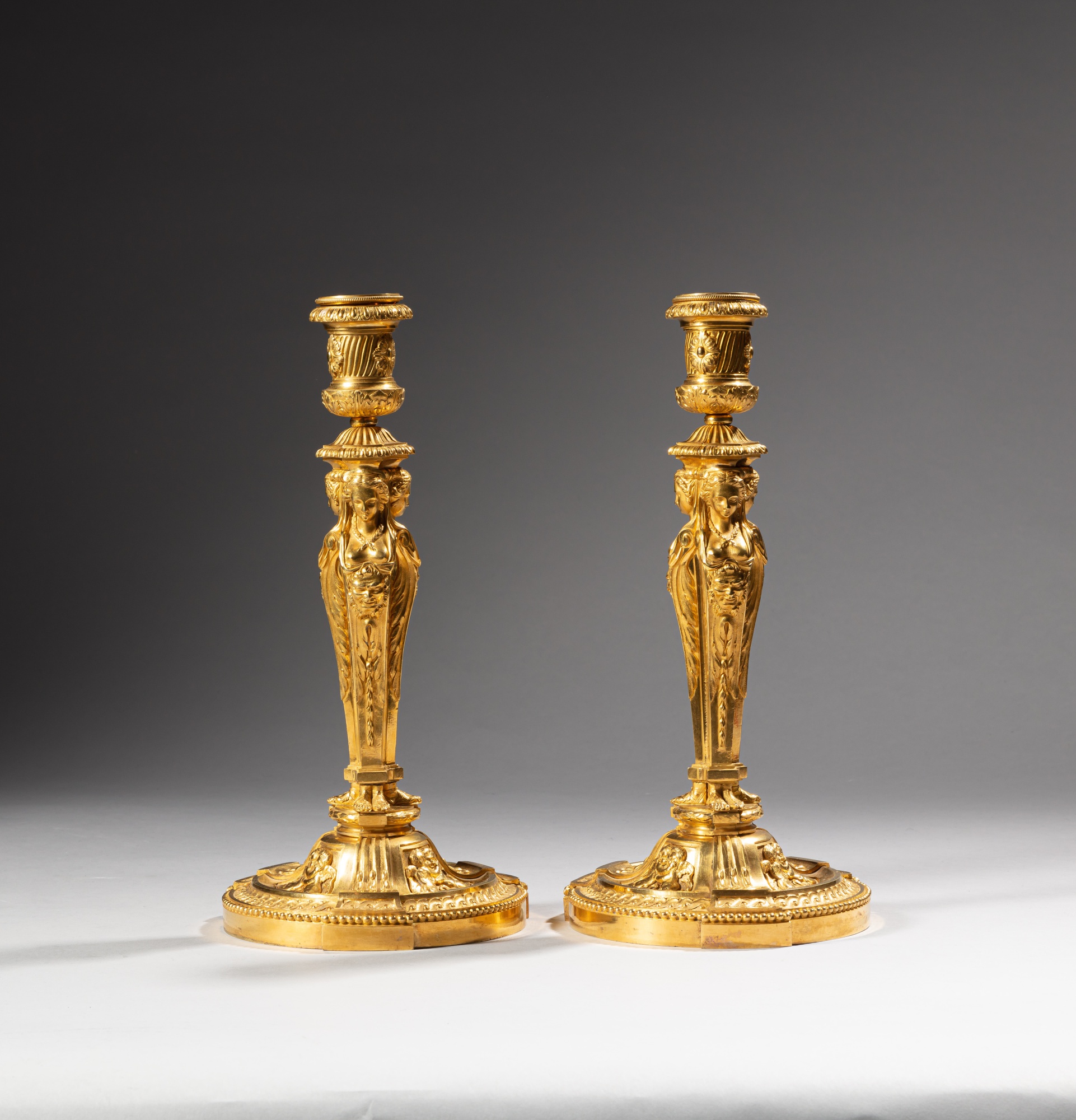 A pair of Louis XVI gilt-bronze candlesticks, circa 1785, attributed to ...