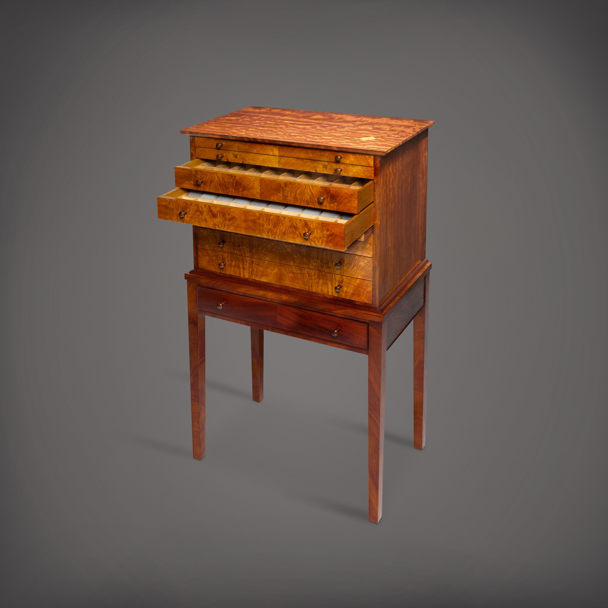 A figured rosewood and mahogany marquetry inlaid watch cabinet on stand ...