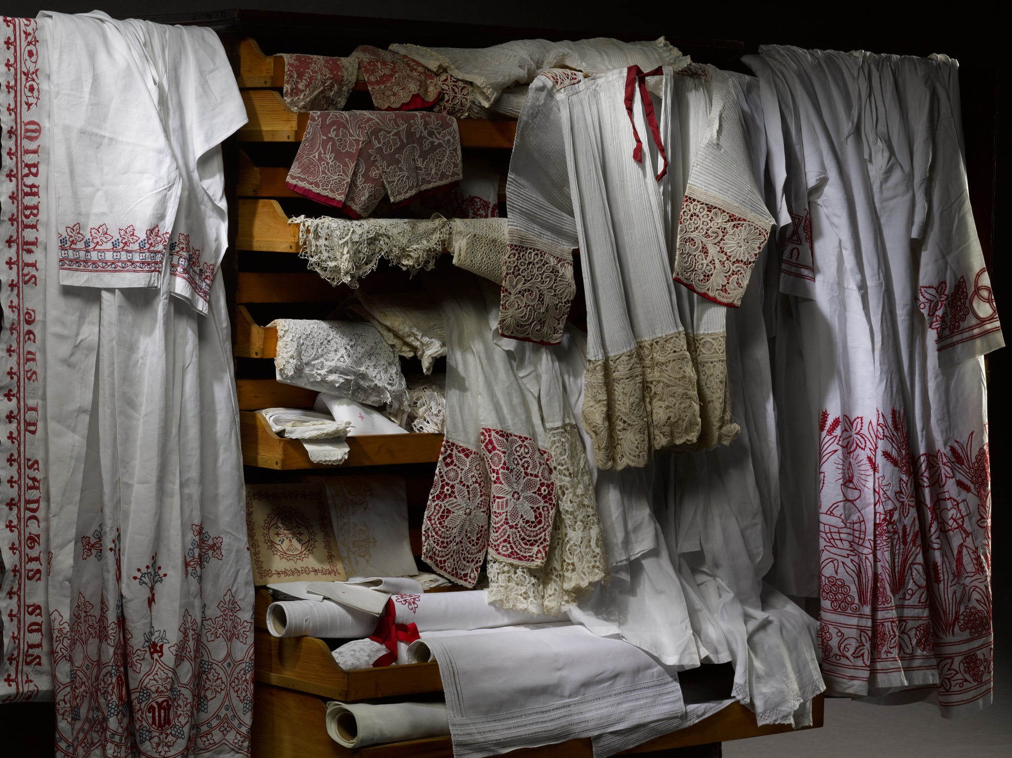 A group of linen and lace vestments and linen church service ...